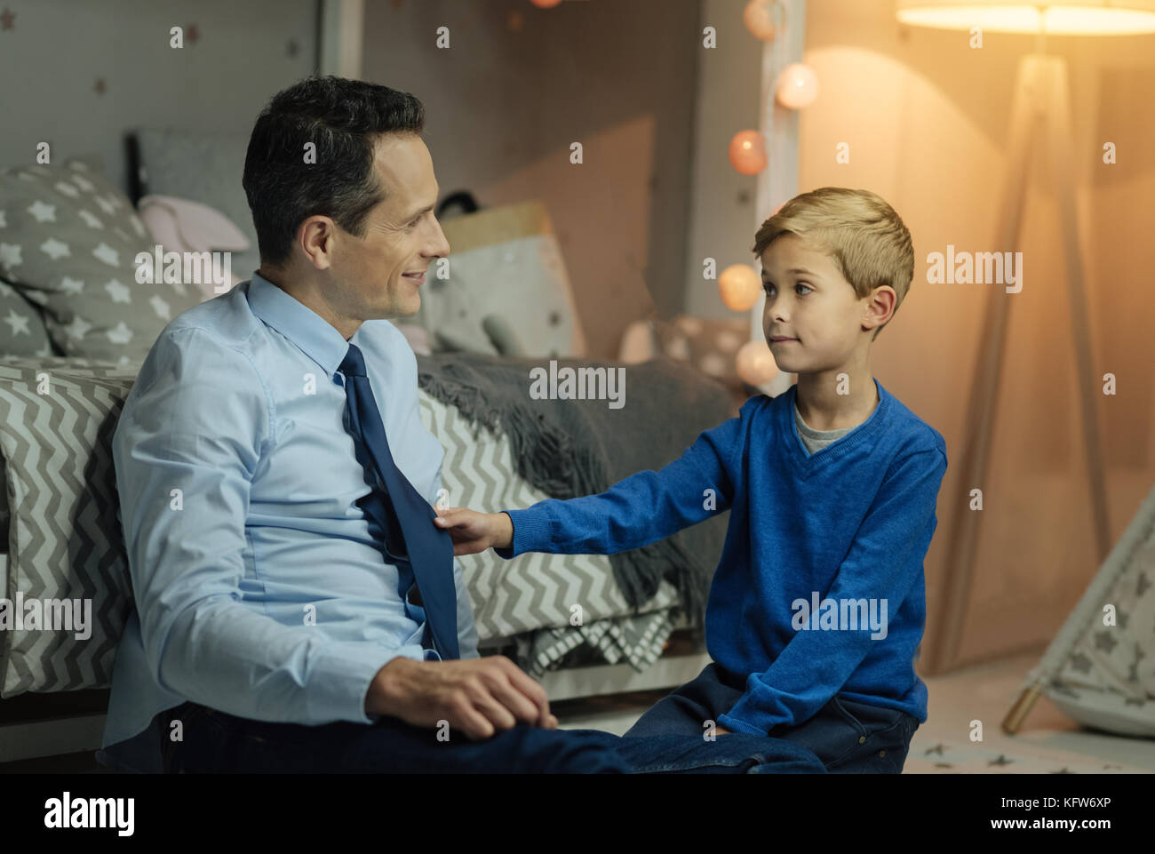 Kind boy touching tie of his dad Stock Photo - Alamy