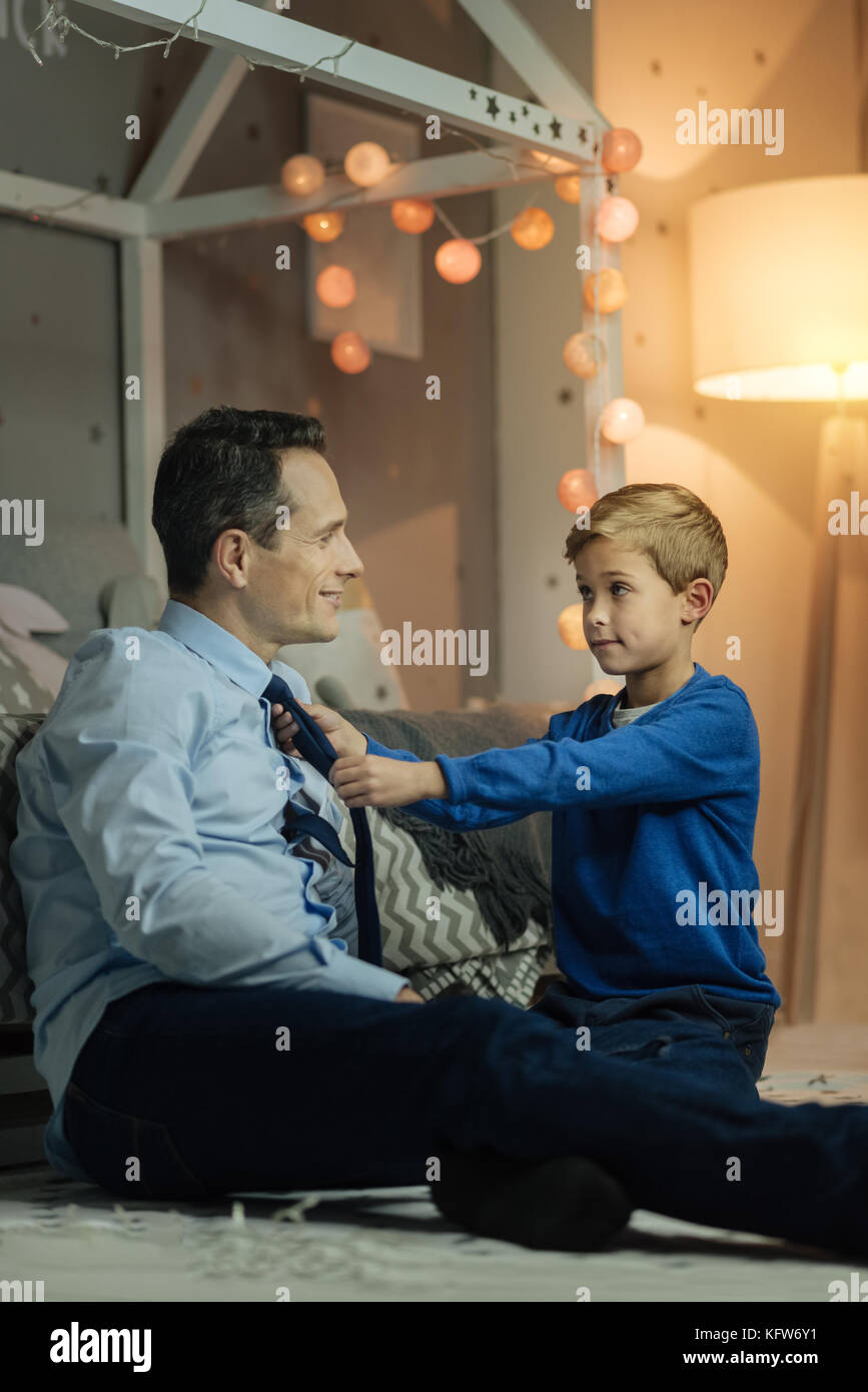 Serious male person sitting in semi position Stock Photo - Alamy