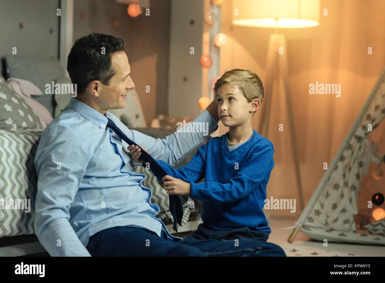 Attentive kid holding stylish tie in both hands Stock Photo - Alamy