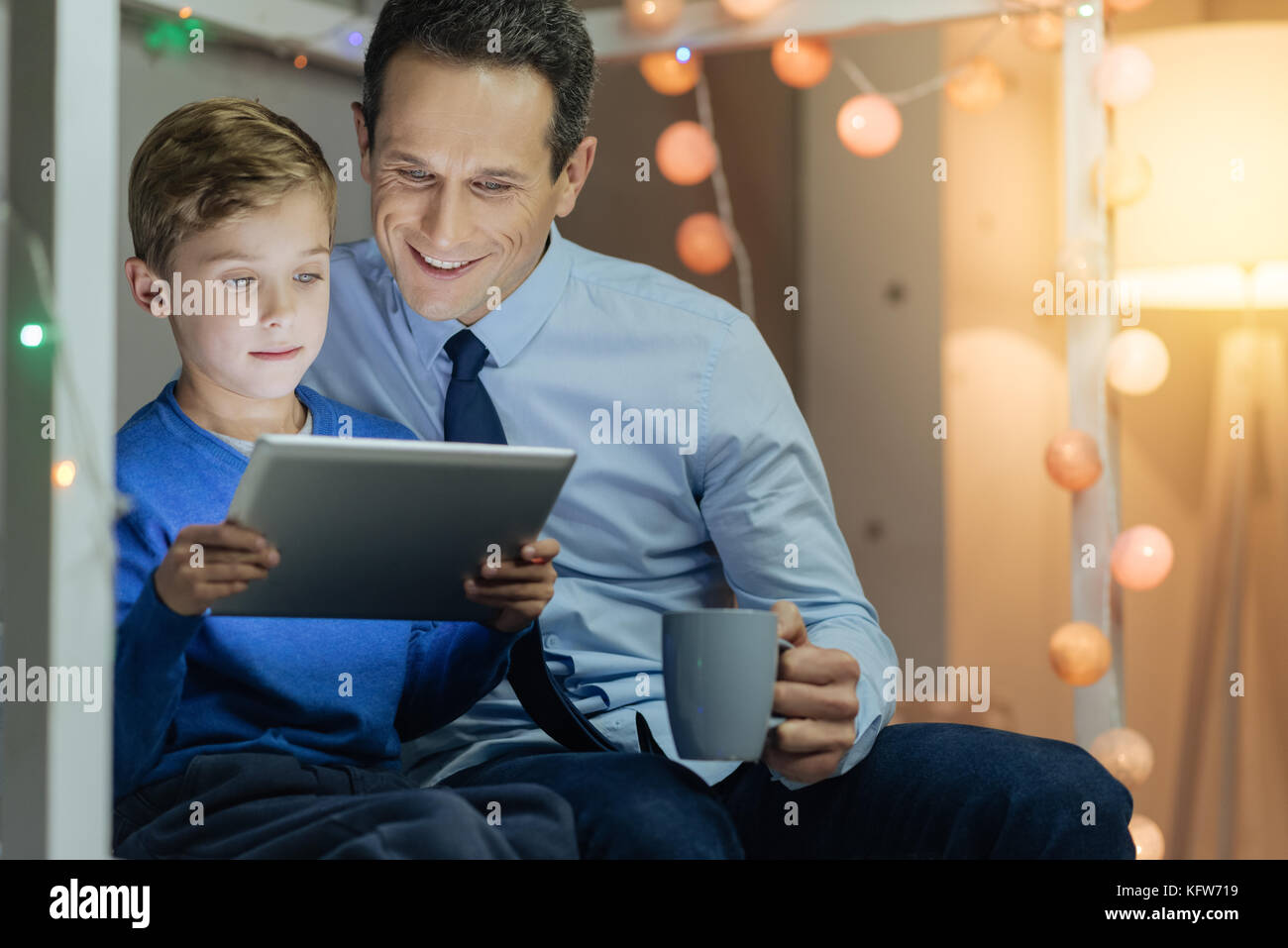 Attentive kid playing with tablet Stock Photo - Alamy