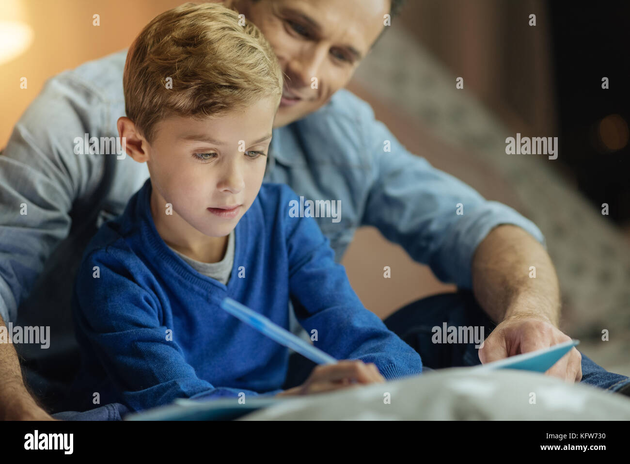 Concentrated boy doing home task Stock Photo - Alamy