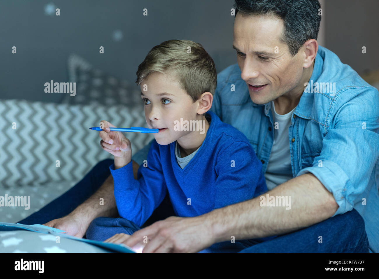 Thoughtful boy biting his pen Stock Photo - Alamy