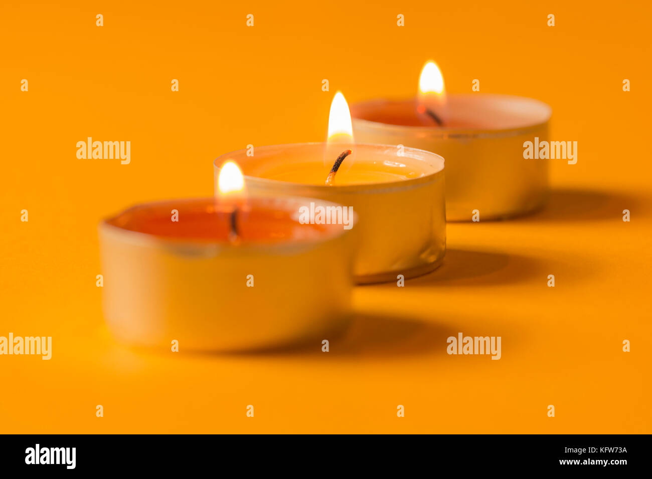 burning tea-lights with soft lights background Stock Photo - Alamy