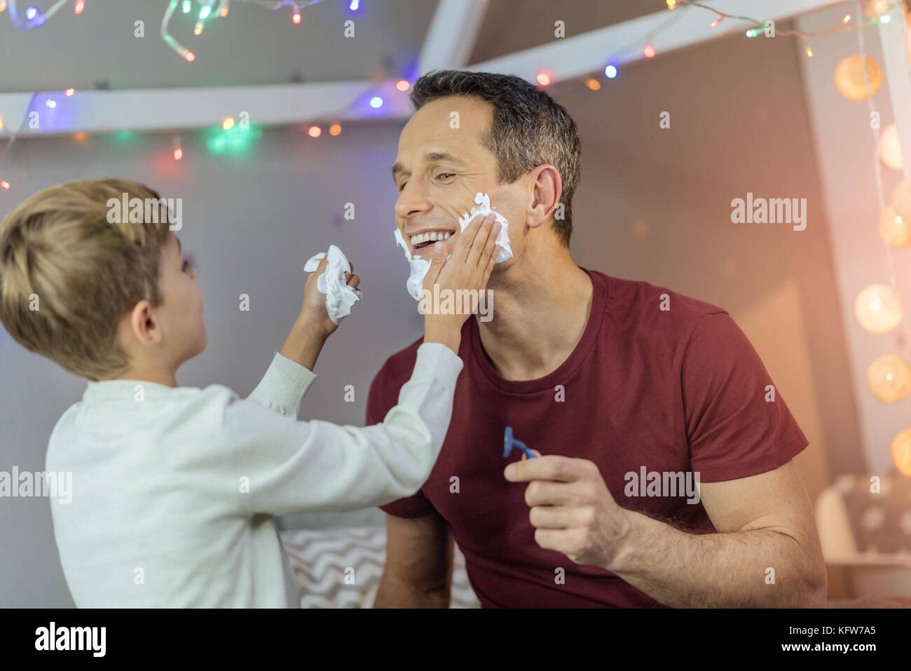 Funny boy helping his father to shave Stock Photo - Alamy