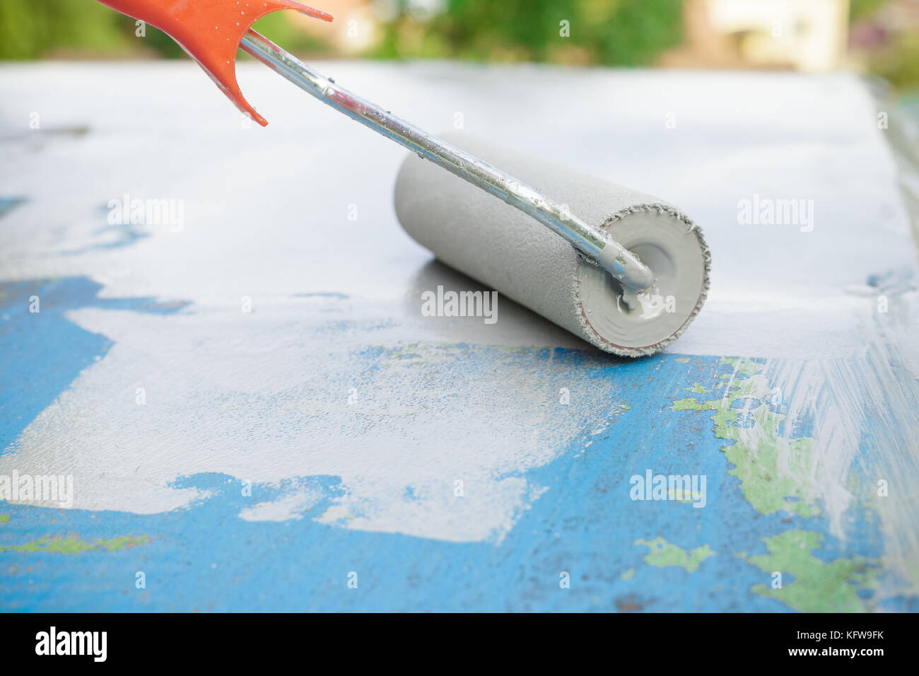 Painting a metal surface with paint primer using a roller. Close up ...