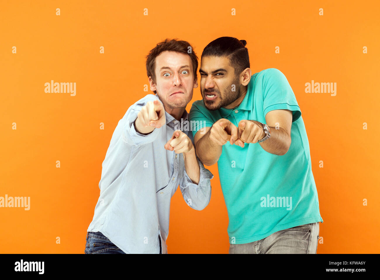 Hey you! Two expressive comic, grimacing at camera. Pointing fingers at ...