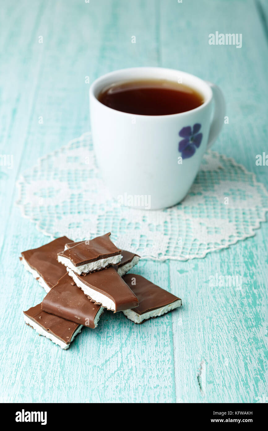 standing on a wooden background cup of tea on lacy napkin beside lie ...