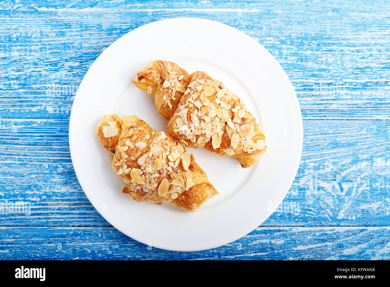 Traditional French breakfast croissant with almonds on a plate Stock ...
