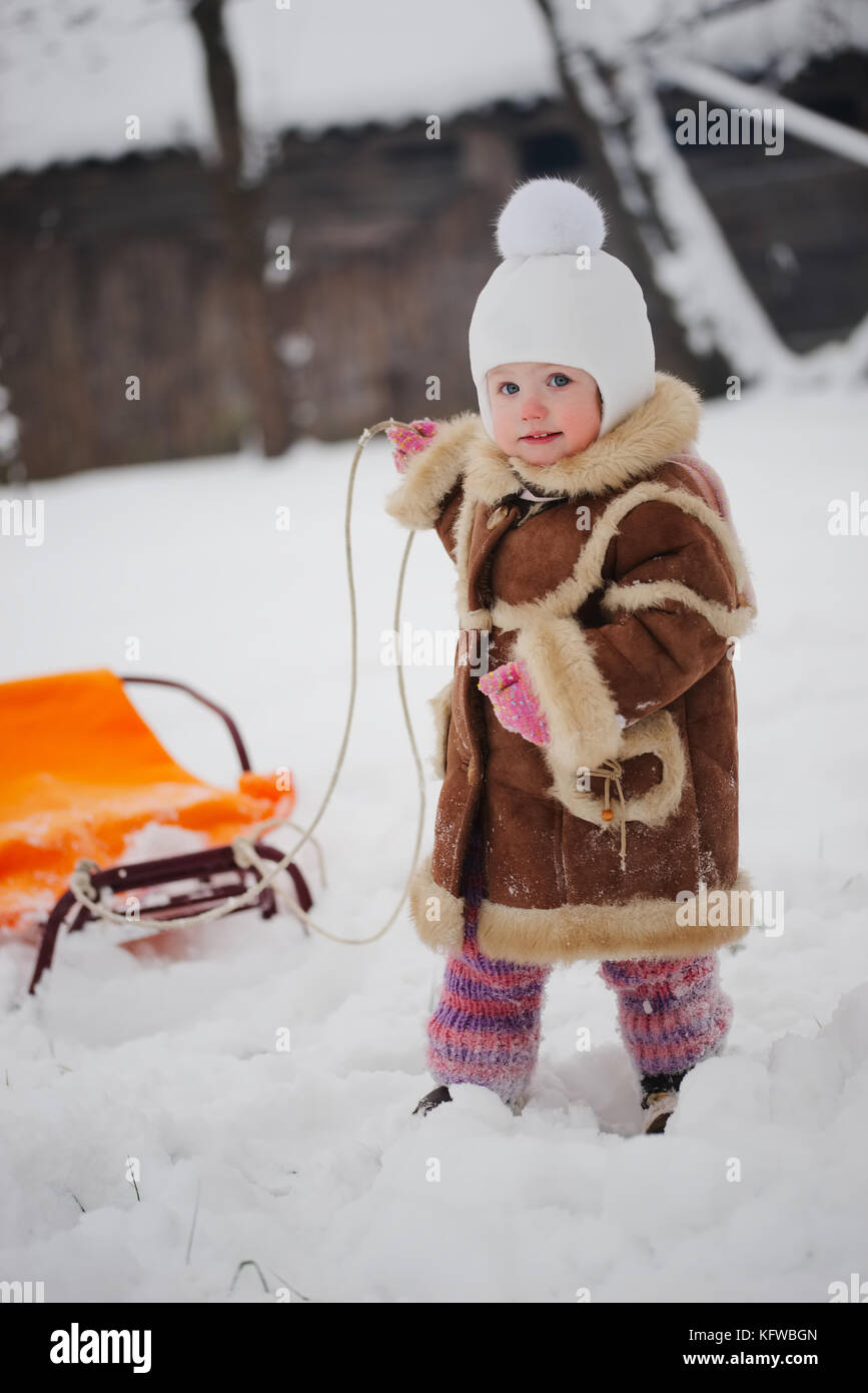 cute girl with sled in snow Stock Photo - Alamy