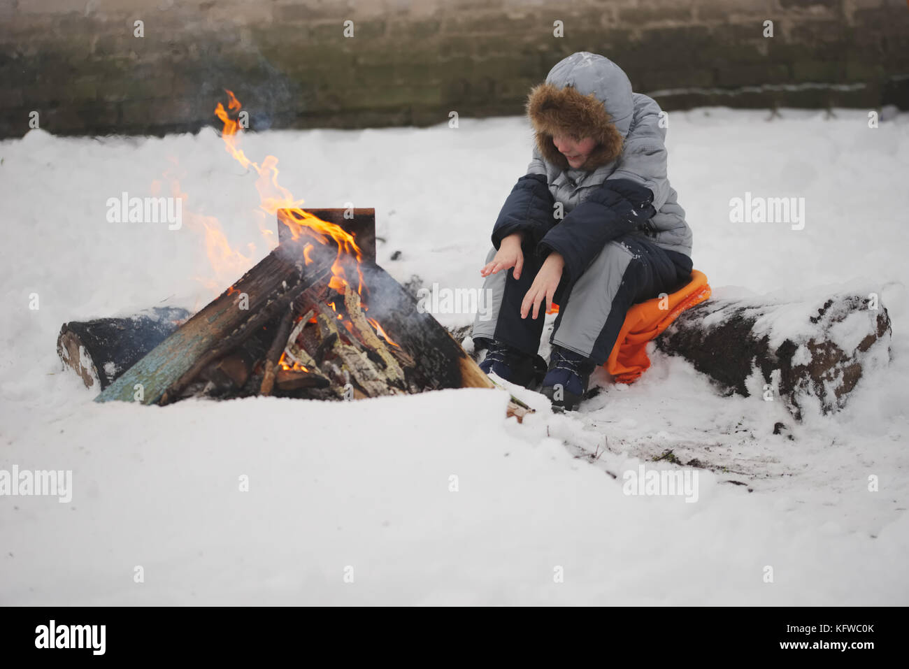 boy sitting by fire in the street Stock Photo - Alamy