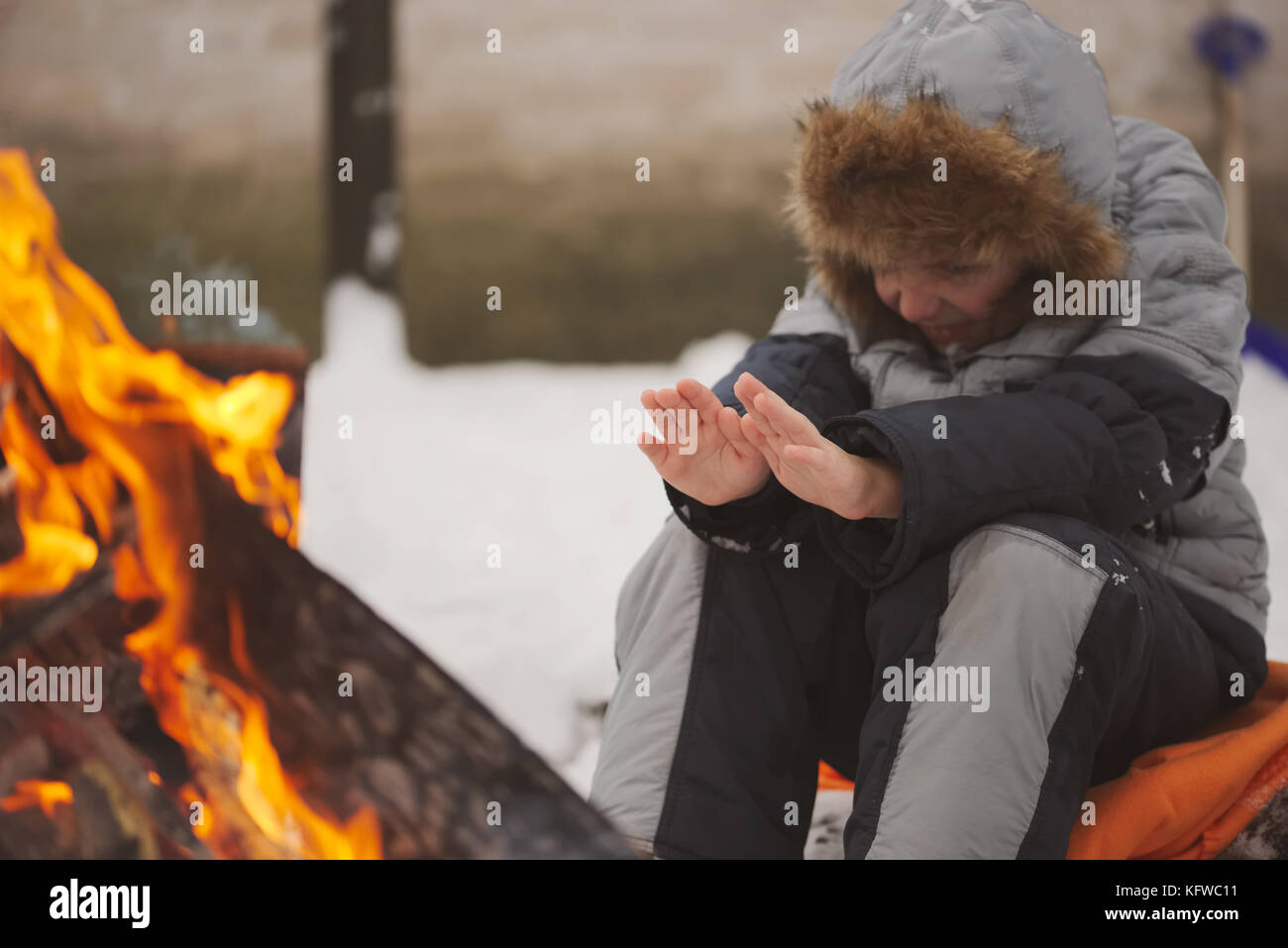 boy sitting by fire in the street Stock Photo - Alamy