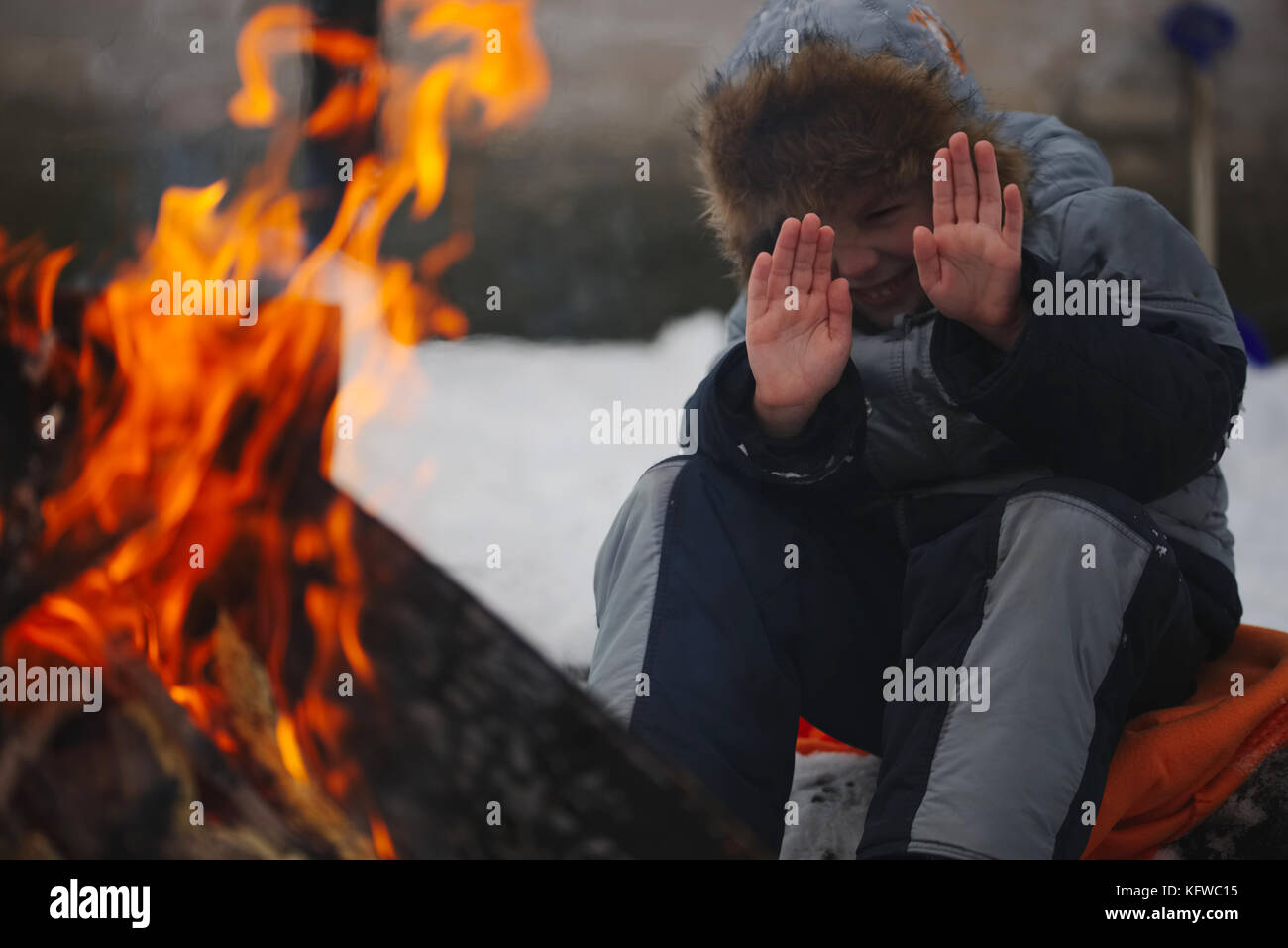 boy sitting by fire in the street Stock Photo - Alamy