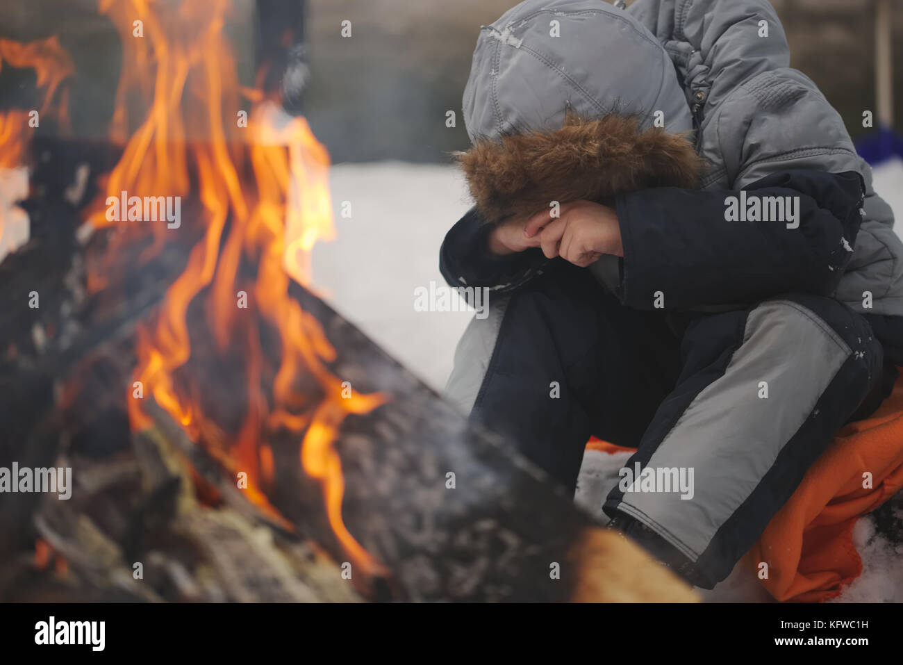 boy sitting by fire in the street Stock Photo - Alamy