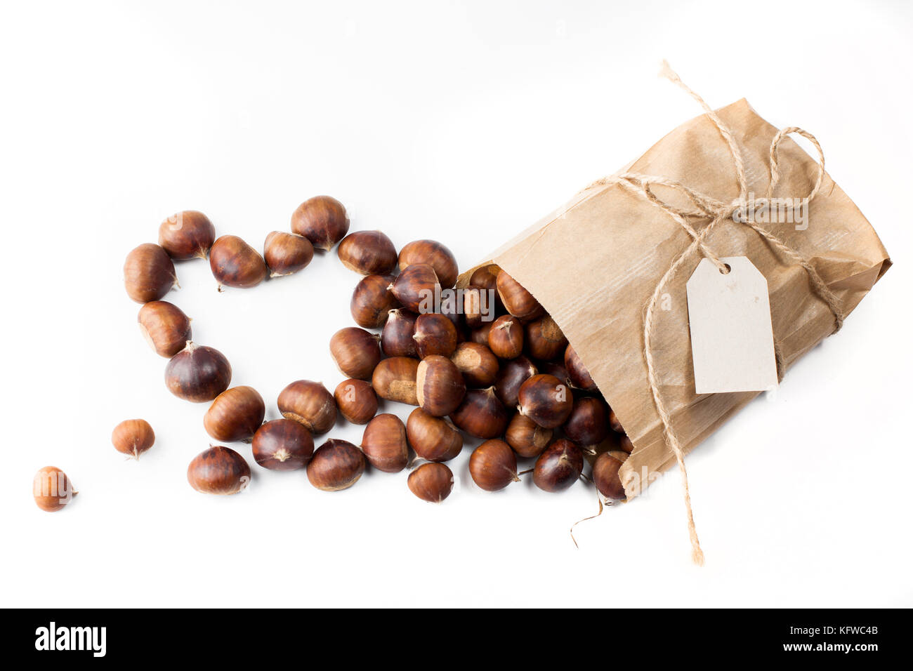edible chestnuts - a bag of fresh, raw chestnuts sprinkled on a white ...
