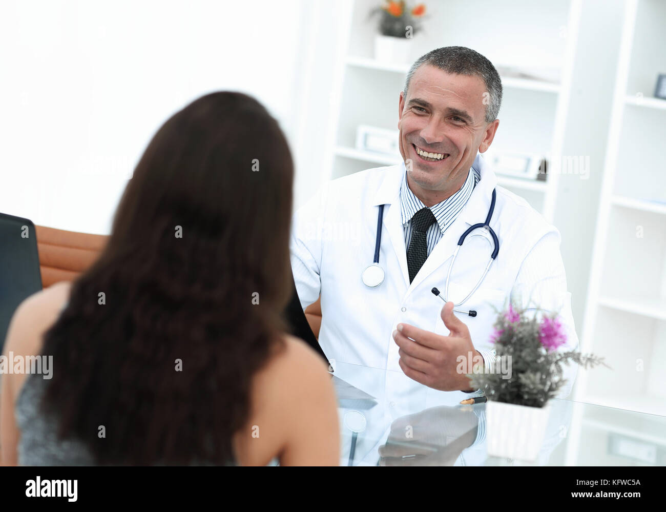 Handsome doctor talking with his patient Stock Photo - Alamy