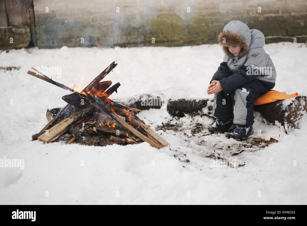 boy sitting by fire in the street Stock Photo - Alamy