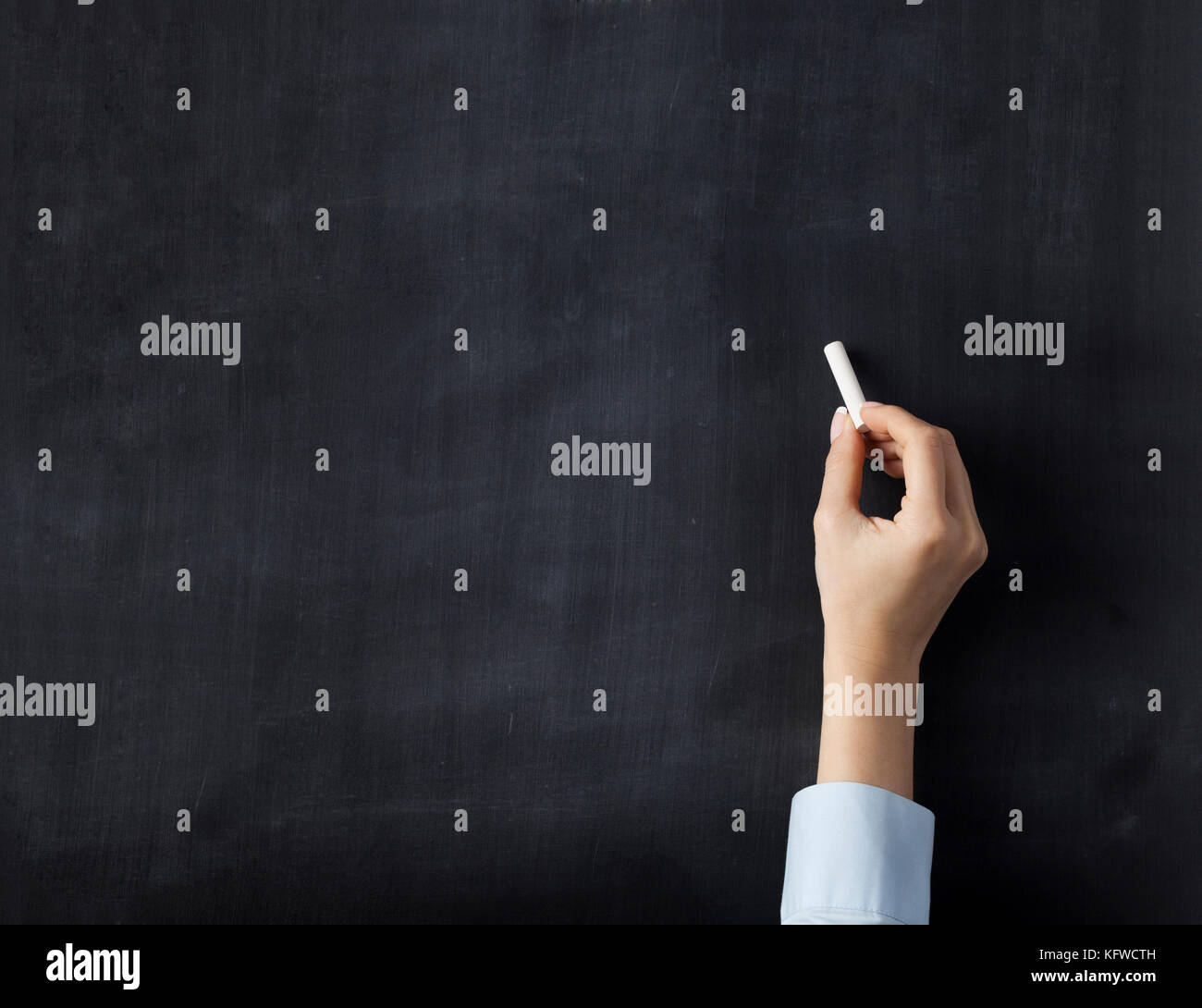 Close up of hand holding chalk on blank chalkboard Stock Photo - Alamy