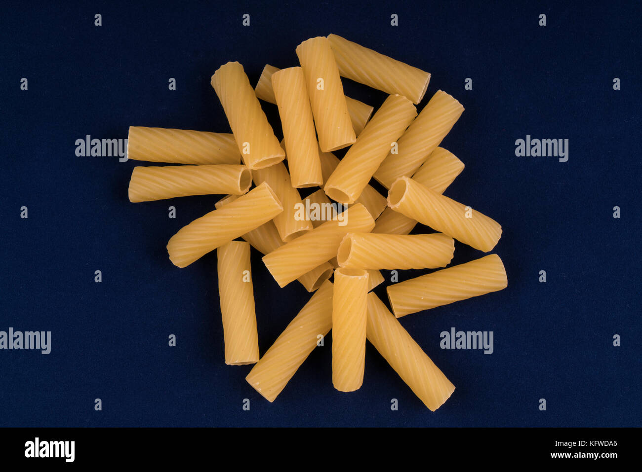 Italian rigatoni pasta on a blue background Stock Photo - Alamy