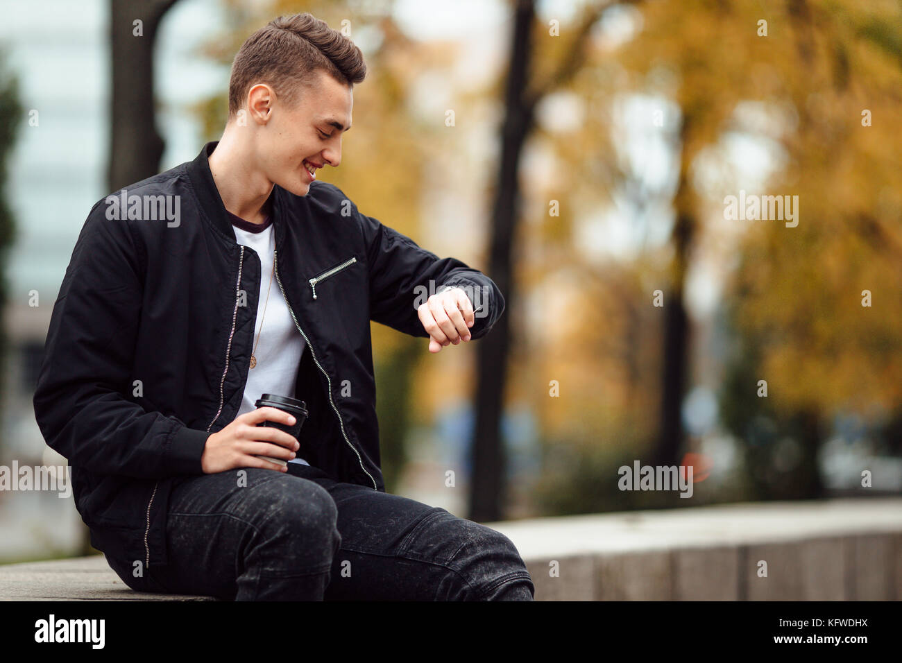 Young boy look at his watch and smile Stock Photo - Alamy