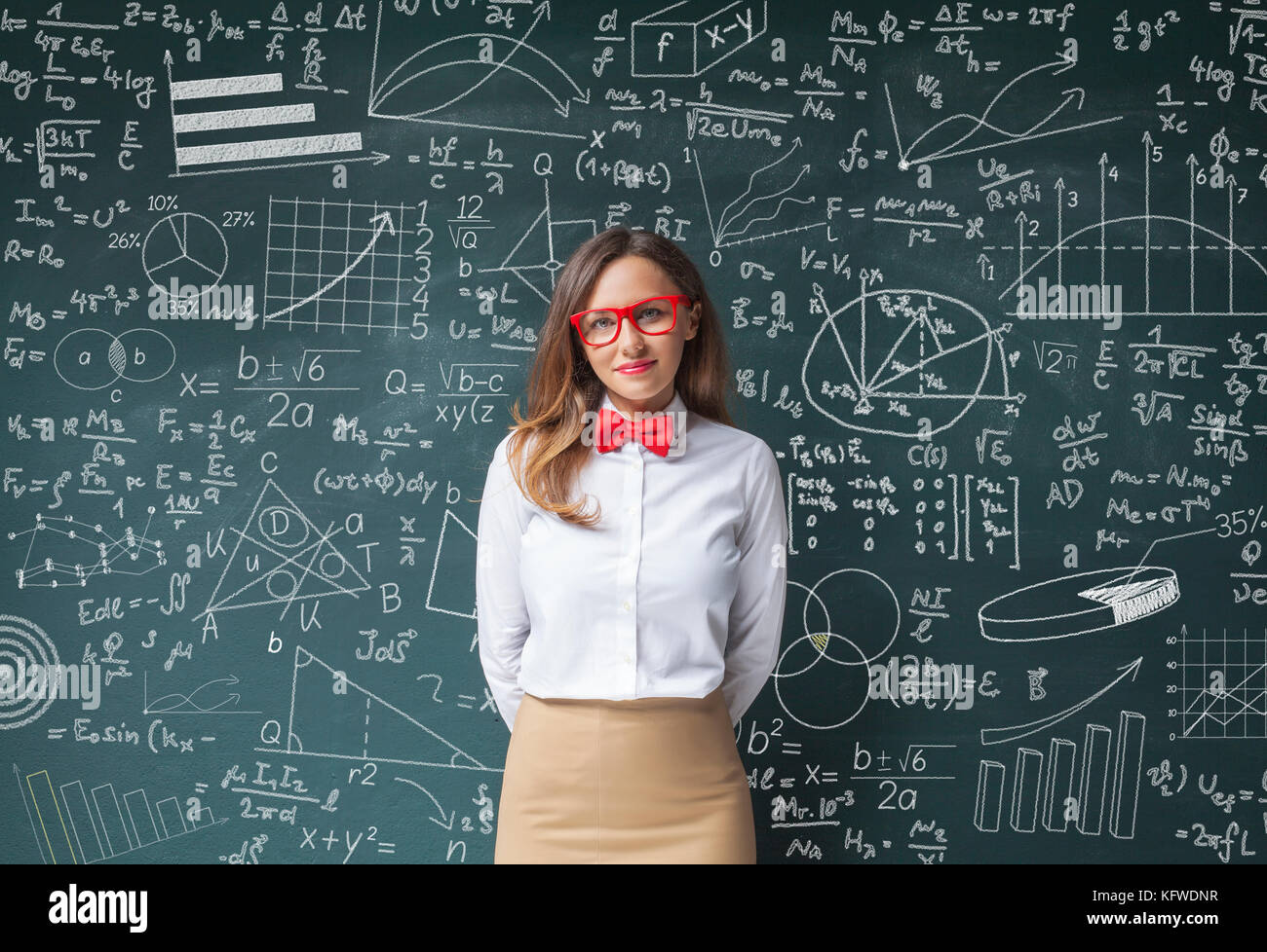 Businesswoman standing near blackboard with formulas and figures Stock ...