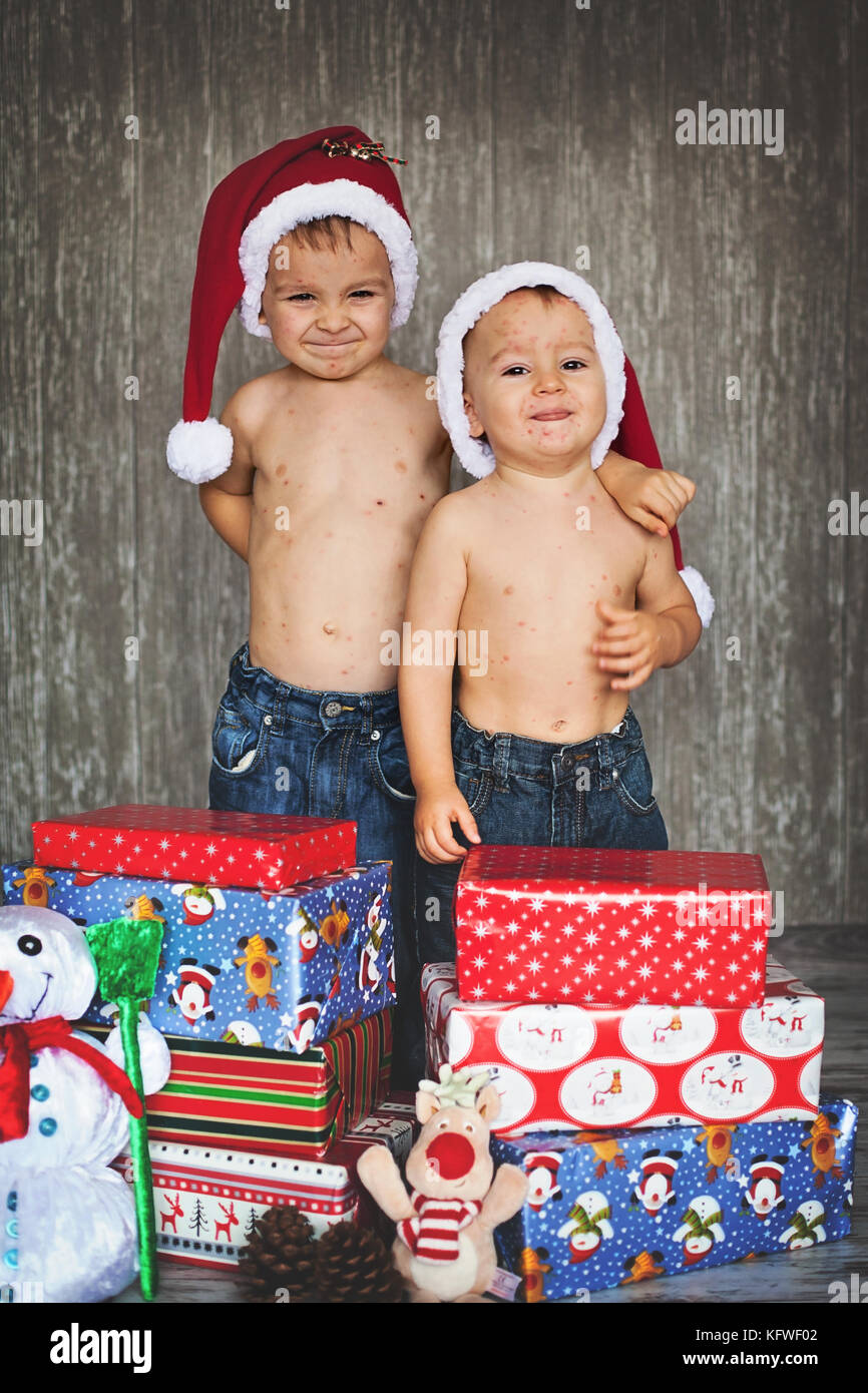 Two brothers with chickenpox on Christmas, happily looking at xmas ...