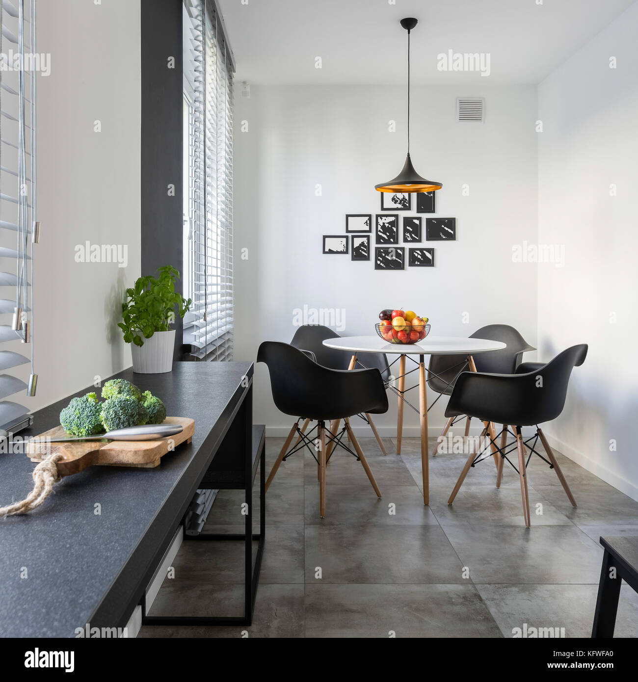 White kitchen with long, granite countertop, round table and chairs ...