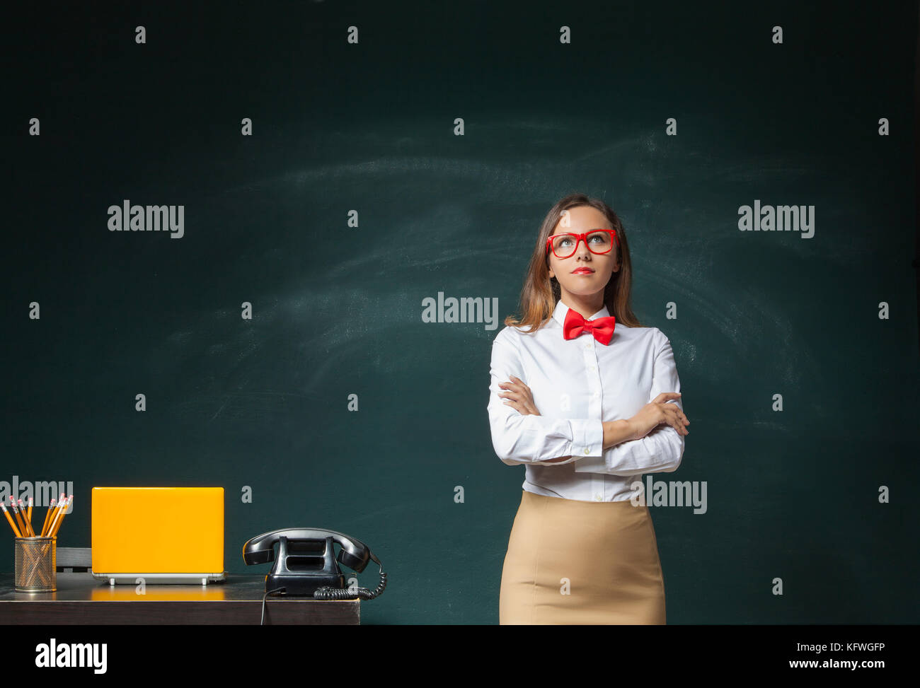 Serious teacher or businesswoman standing with arms crossed at ...