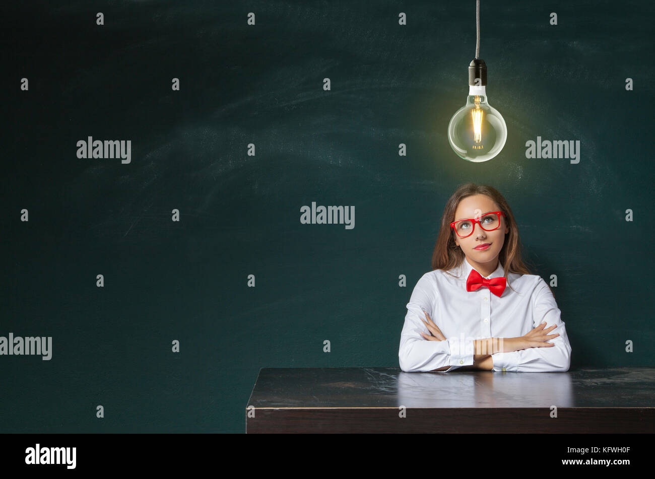 Young woman is looking for ideas under light bulb Stock Photo - Alamy