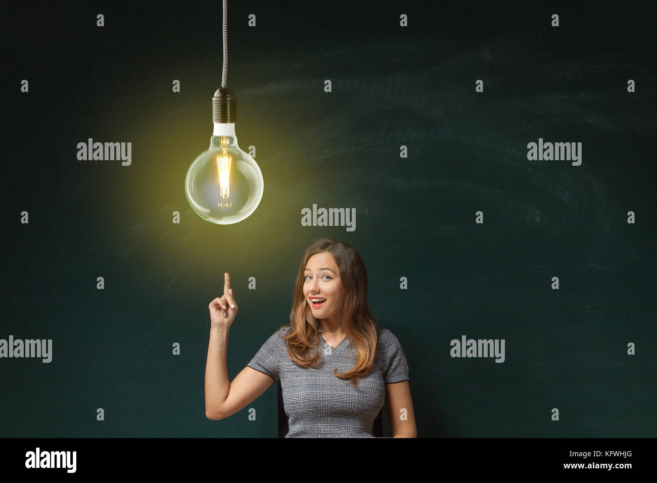 Young student pointing light bulb on blackboard background Stock Photo ...