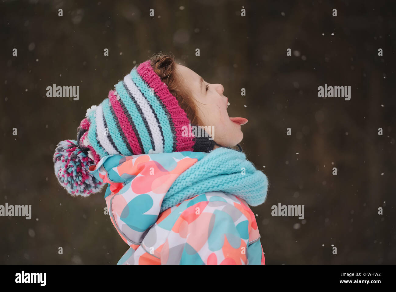 little girl catching snowflakes in winter park Stock Photo - Alamy