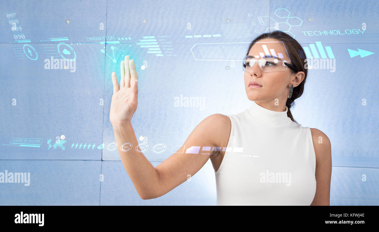 A young brunette woman in a white high-tech dress is wearing smart ...