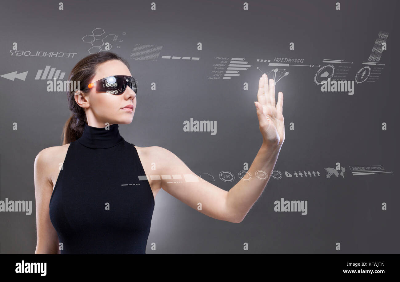 Young woman in a black high-tech dress is wearing smart glasses and ...