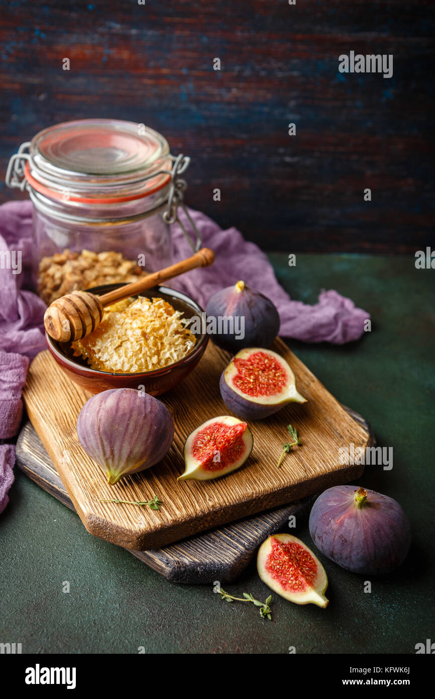 Juicy fresh whole fig fruits and one cut figs and bowl of honey in ...