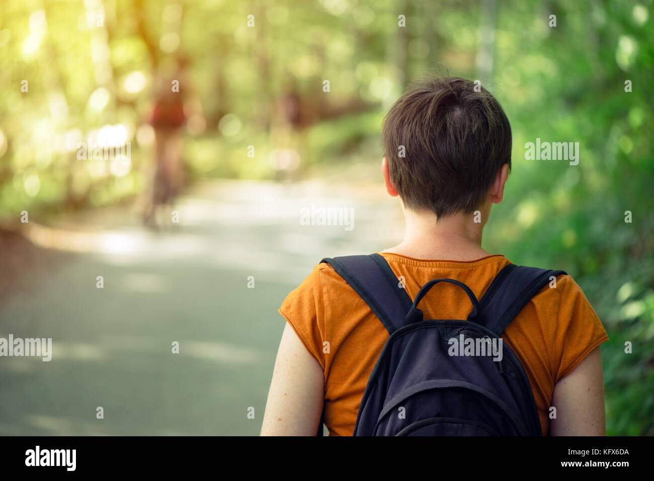 Rear view of adult caucasian female with backpack enjoying a walk in ...