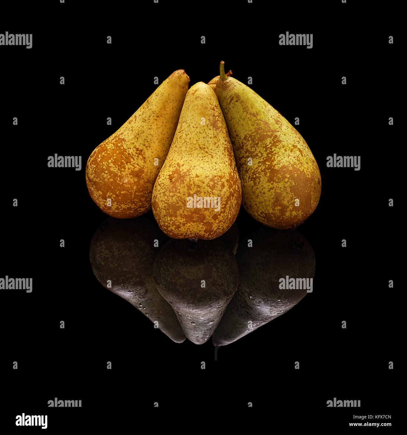 Three whole ripe pears isolated on black glossy background with real ...