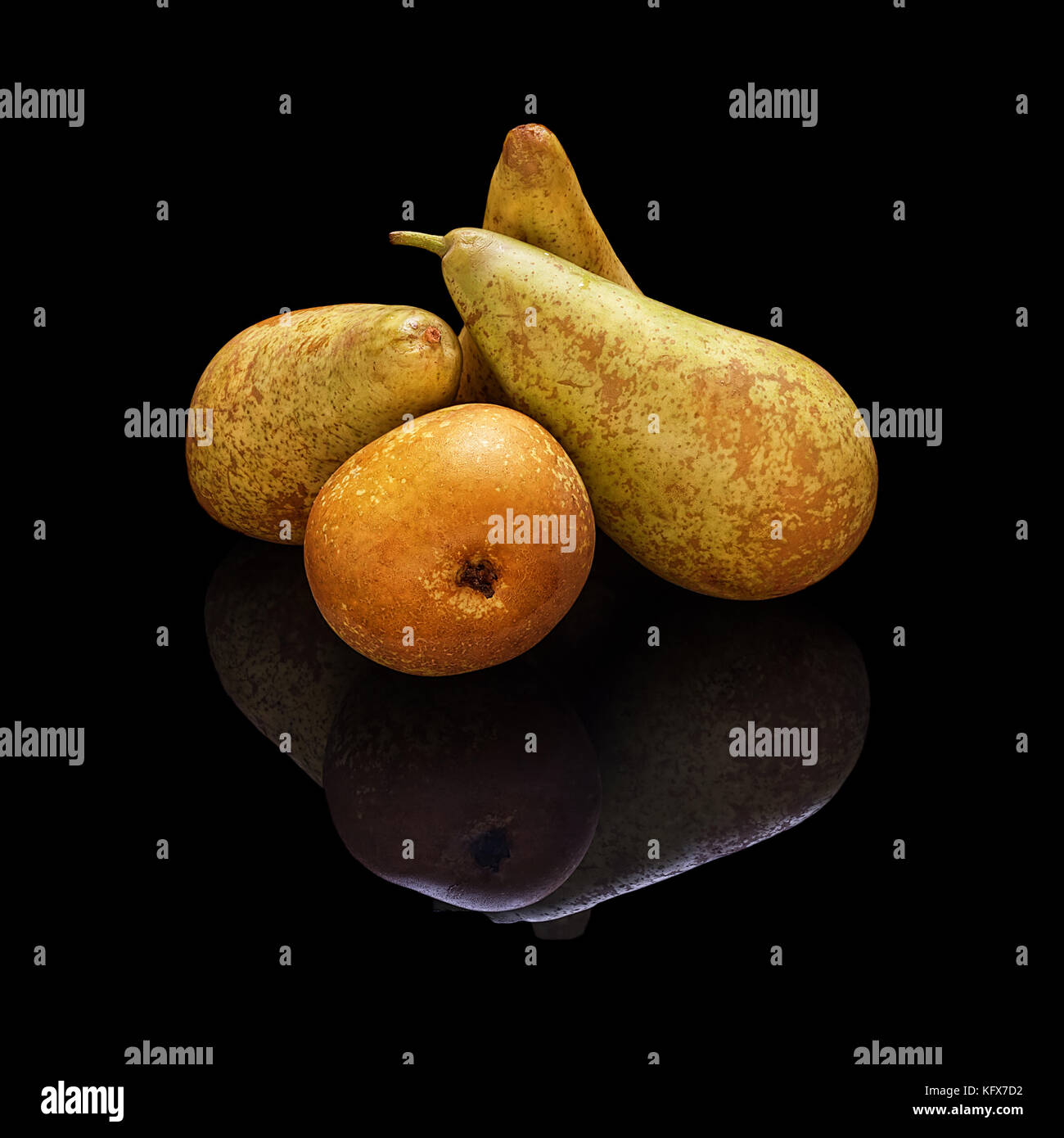 Four whole ripe pears isolated on black glossy background with real ...