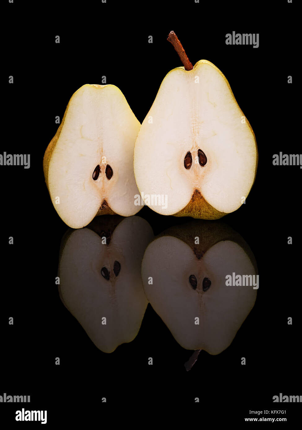 Two half-cut pear isolated on black glossy background with real ...