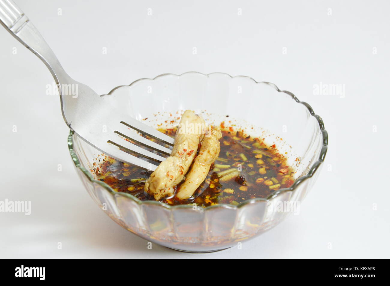 roast chicken stab on fork dressing in spicy sauce Stock Photo - Alamy