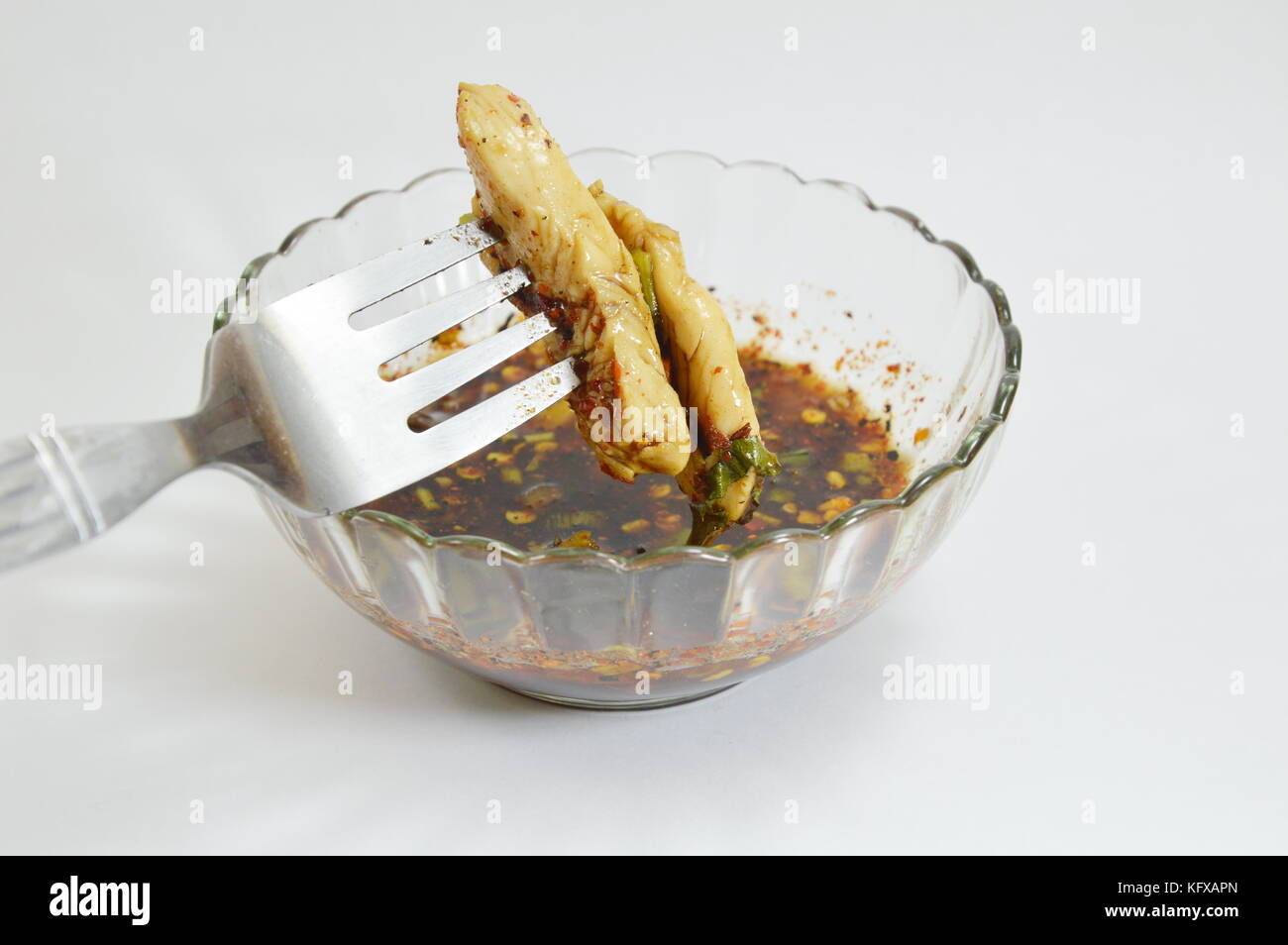 roast chicken stab on fork dressing in spicy sauce Stock Photo - Alamy