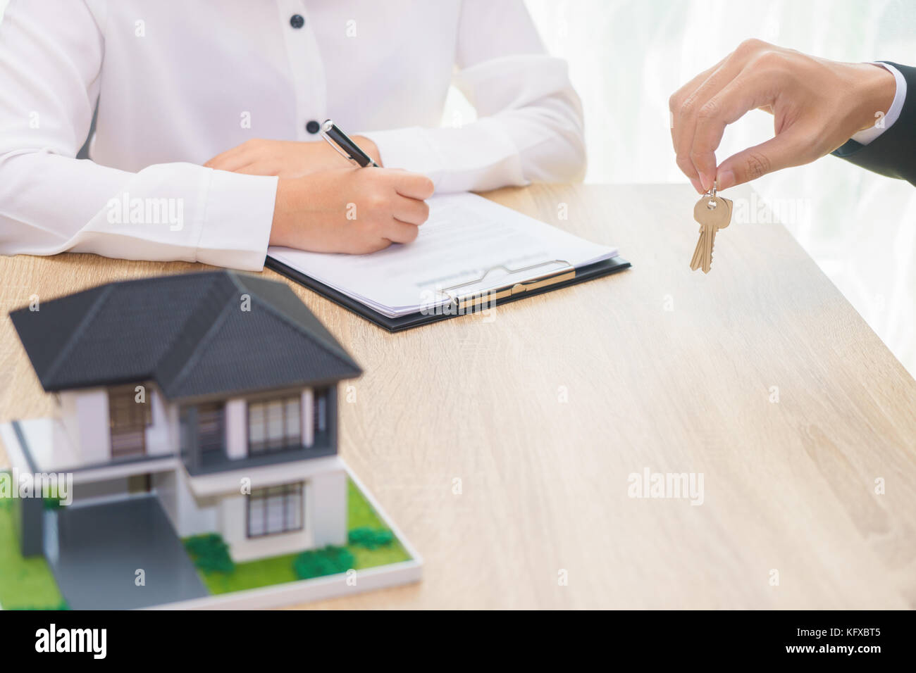 Woman signing contract or home loan agreement document with businessman ...