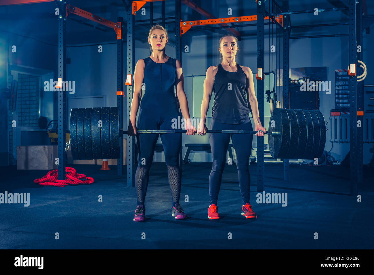 Fit young women lifting barbells and working out in a gym Stock Photo ...
