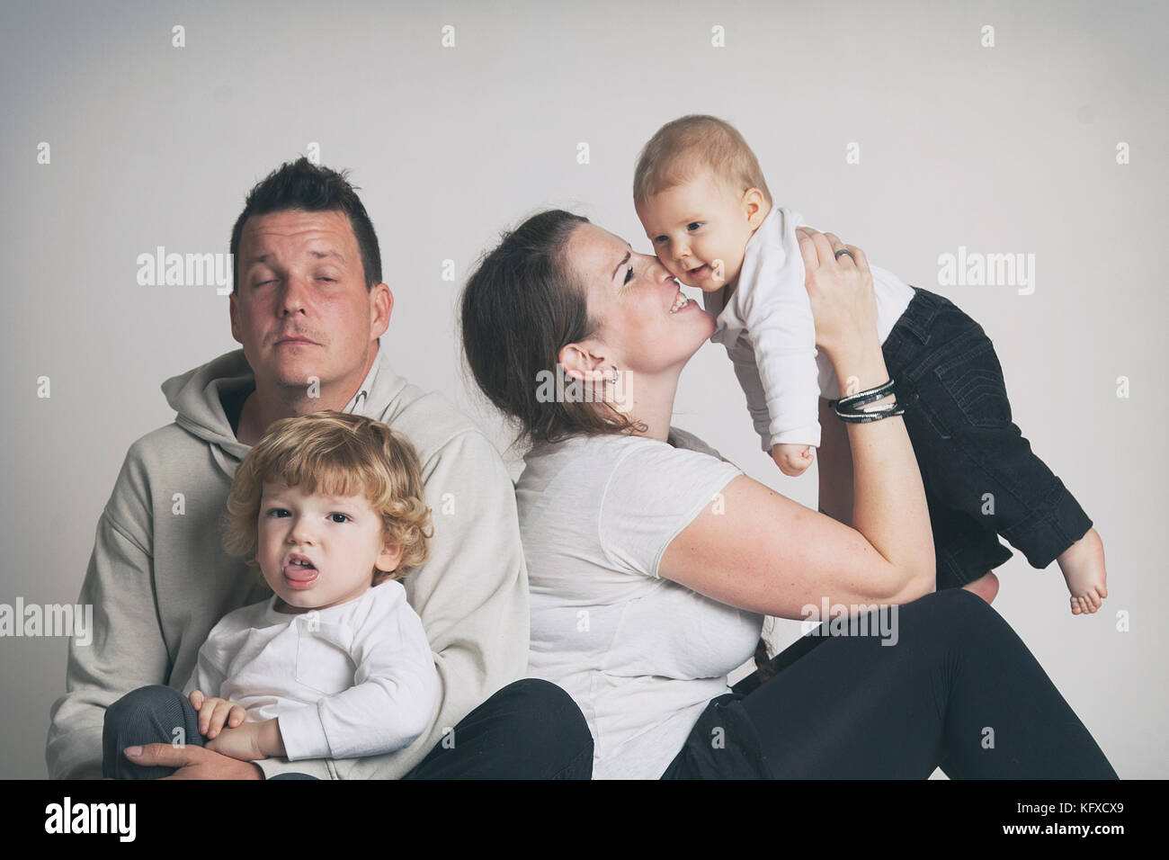 Two generation family studio portrait on grey and white background ...