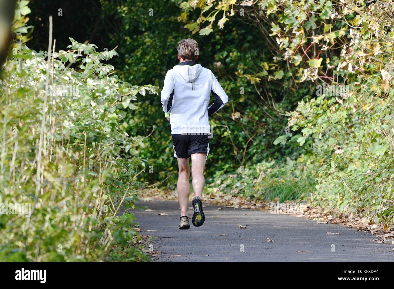 A young man runs along a path next to the River Mersey, Heaton Mersey ...