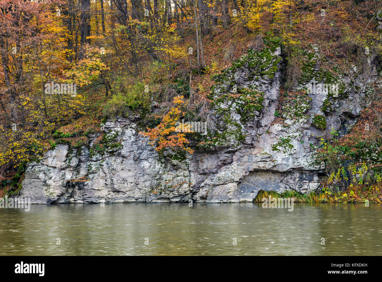 rocky cliff above the river in autumn forest. stunning nature scenery ...