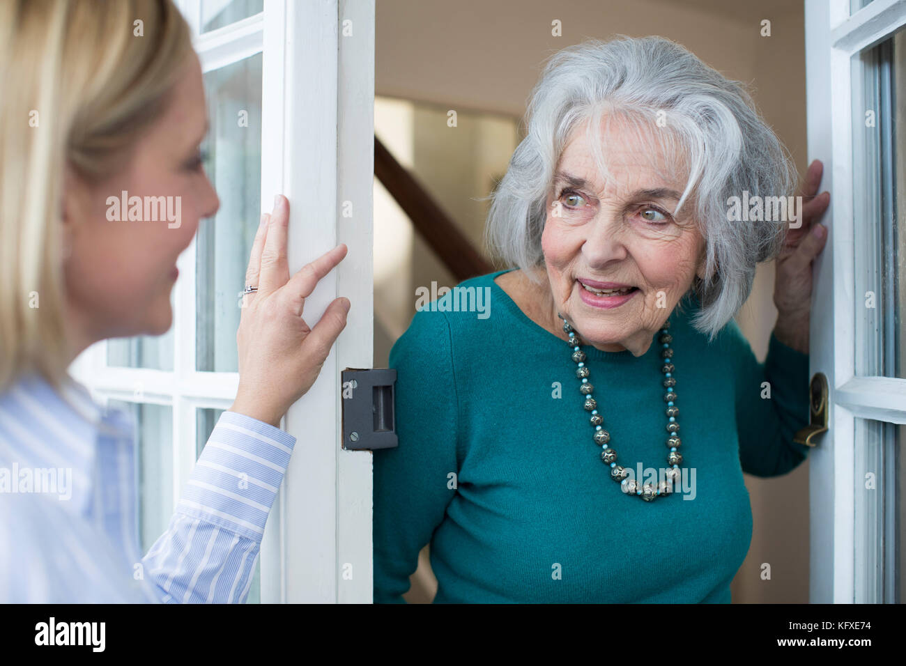 Woman Checking On Elderly Female Neighbor Stock Photo - Alamy