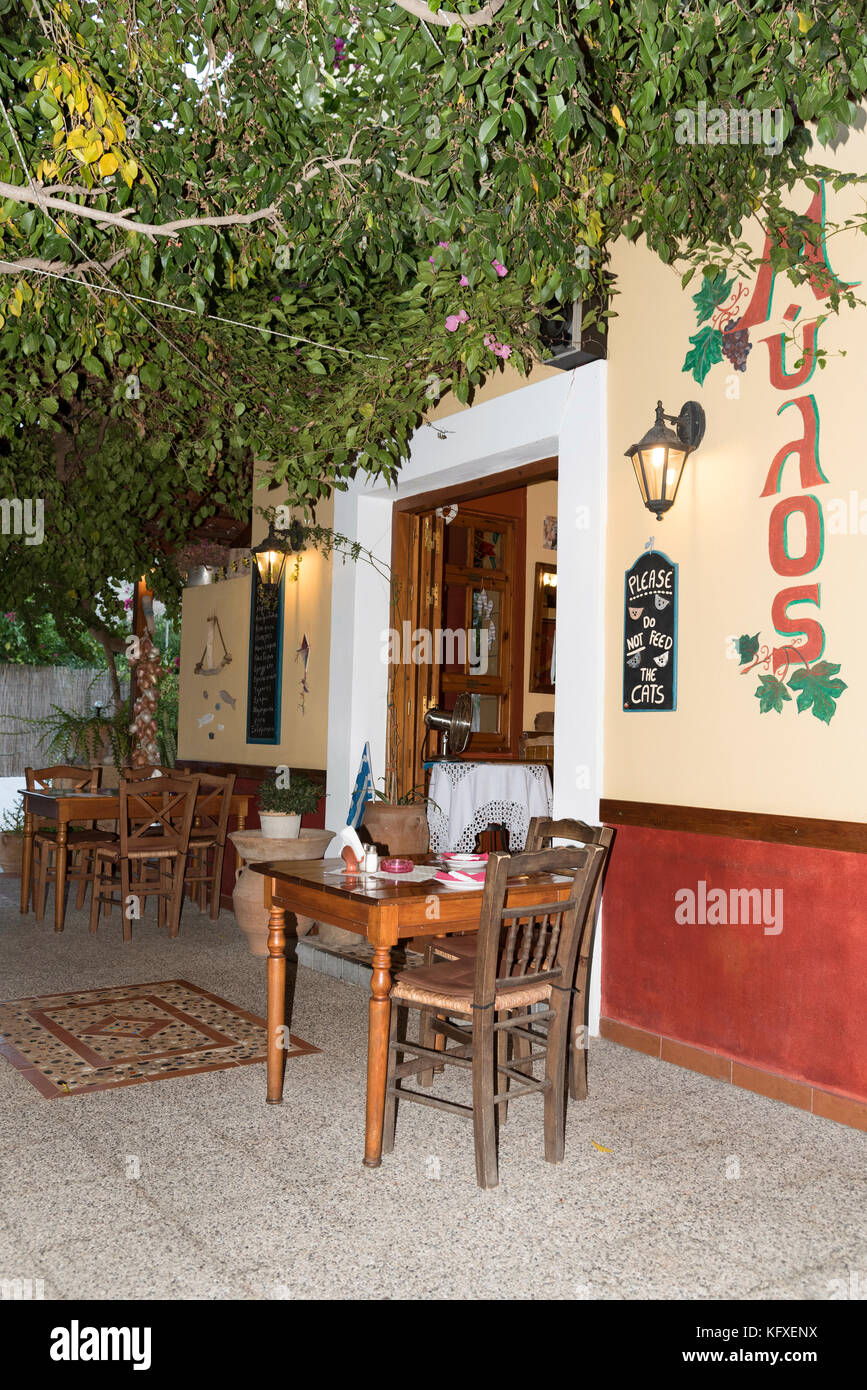 Greek taverna in Crete, Greece. A menu and a sign requesting customers ...