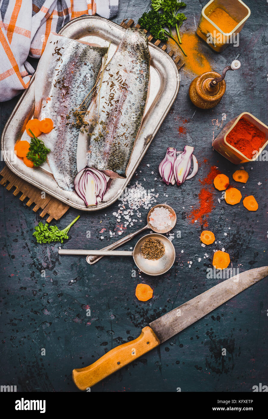 Raw fish fillets with kitchen knife , spices and cut vegetables ...