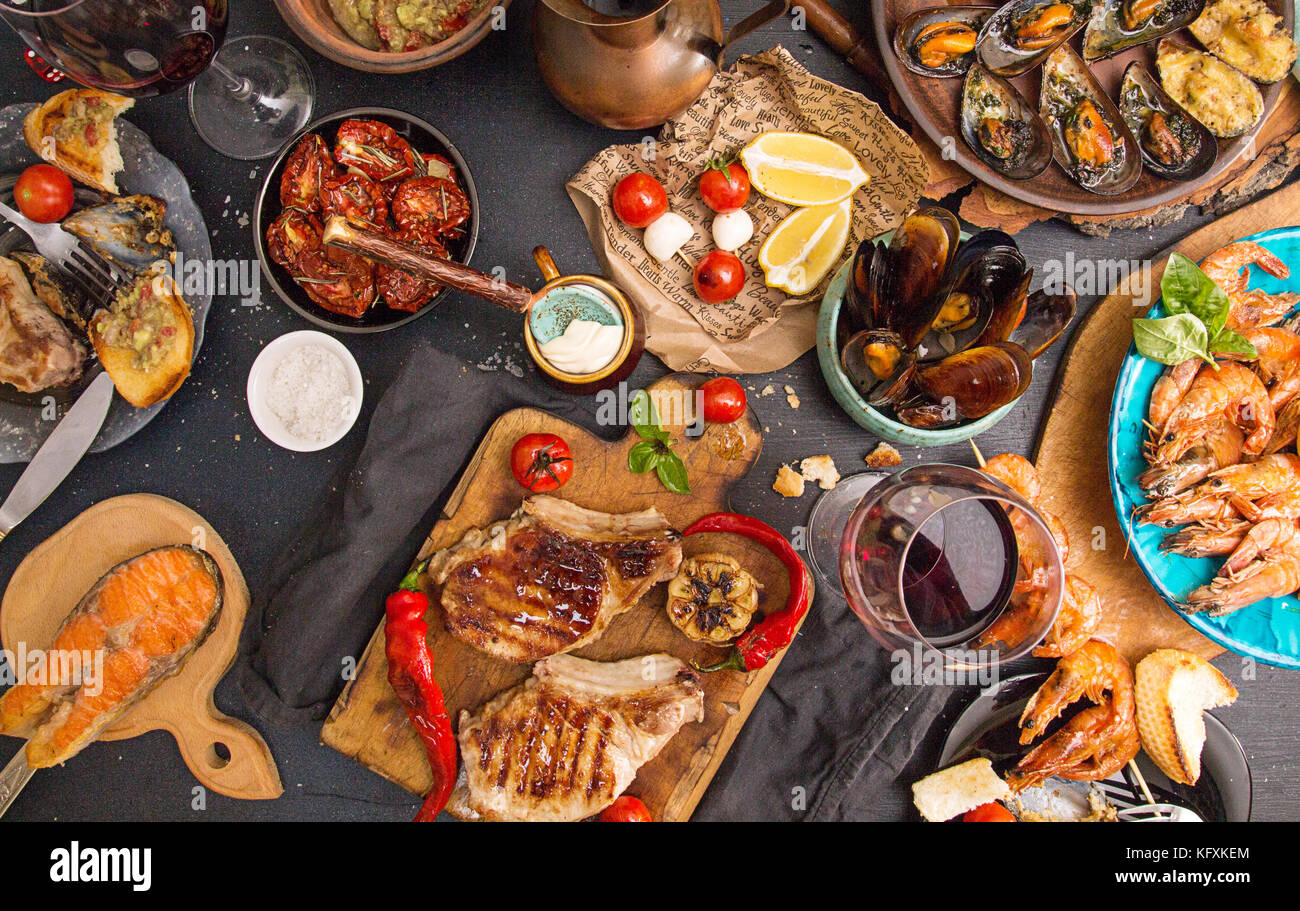 Overhead of bbq dinner table. Assorted grilled barbecue meat and ...
