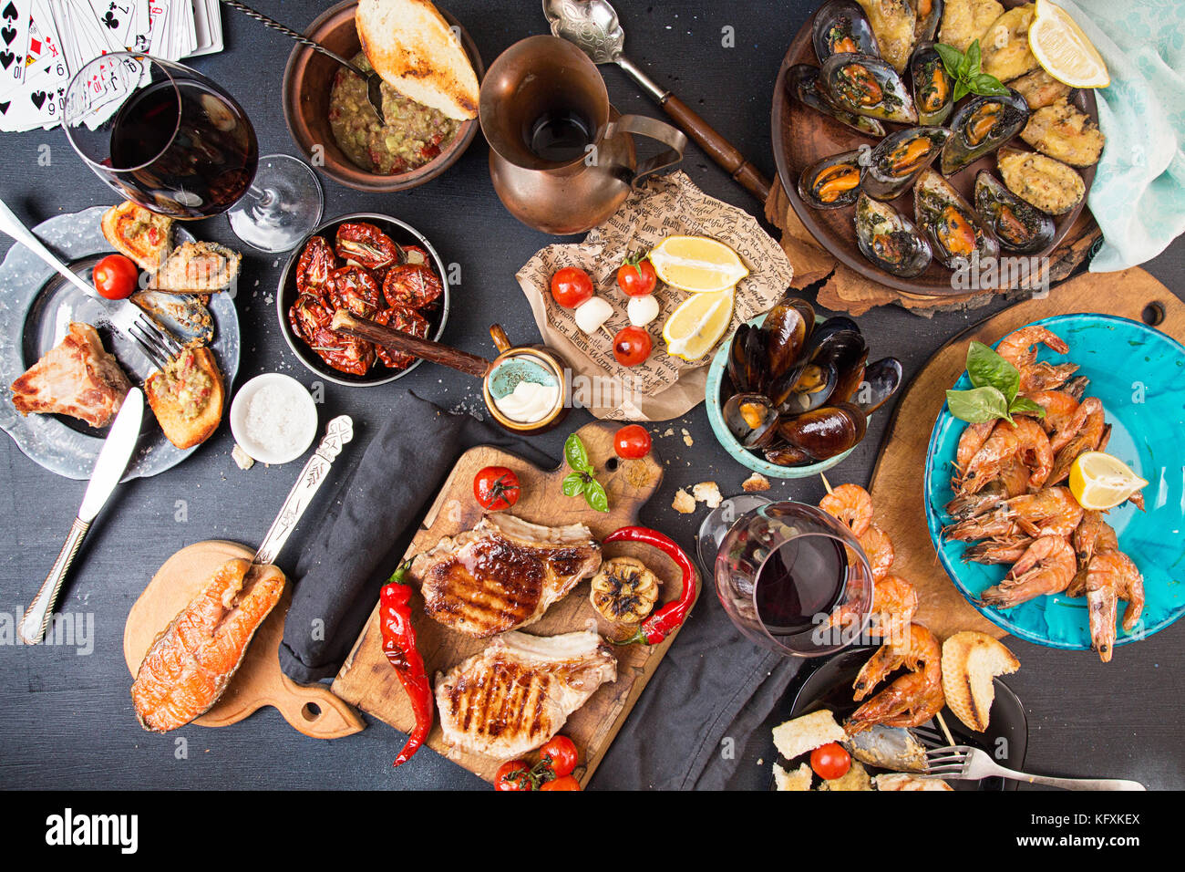Overhead of dinner table. Assorted delicious grilled barbecue meat and ...