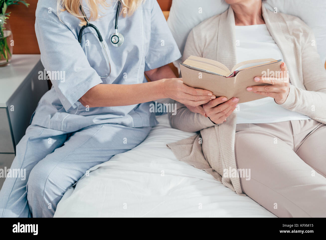 nurse and senior patient with book Stock Photo - Alamy